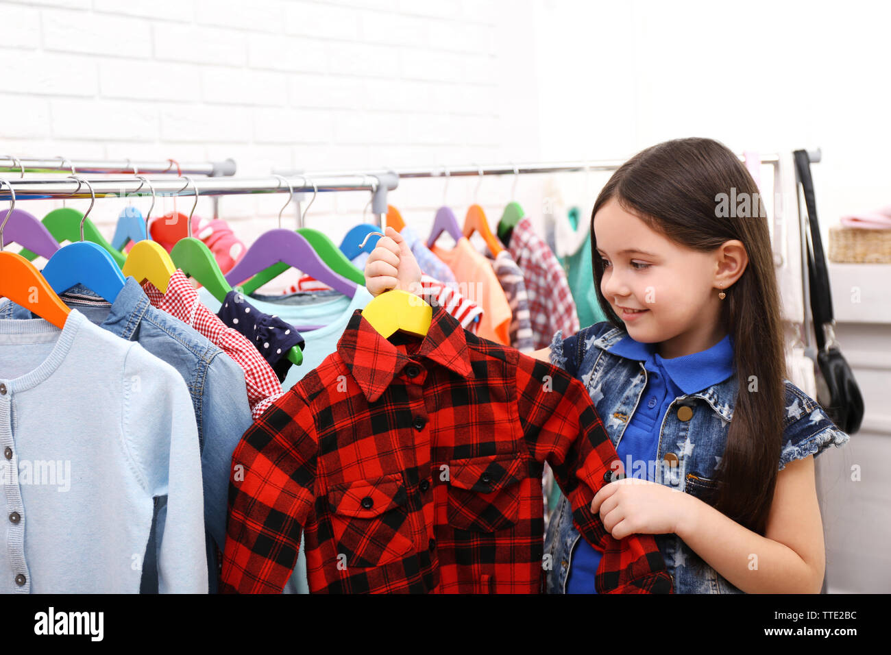 Little girl trying on a new shirt Stock Photo - Alamy