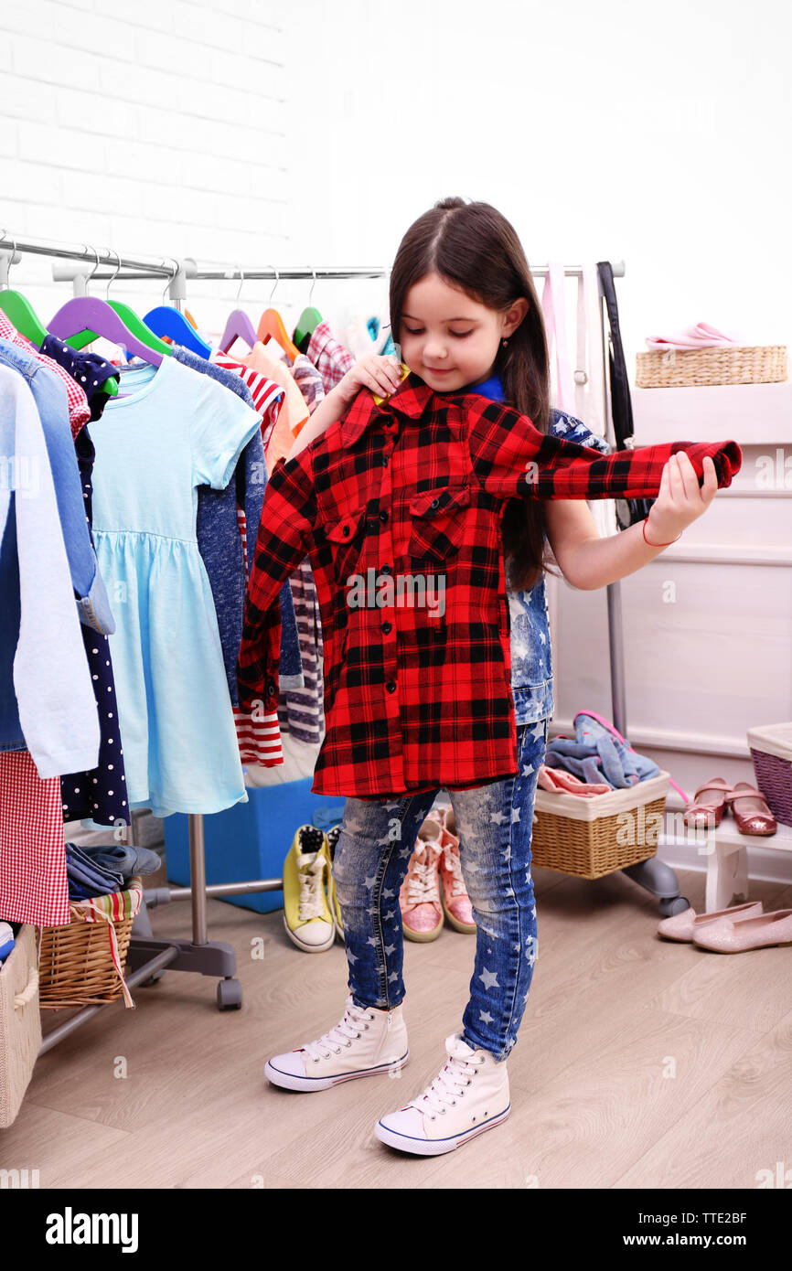 Little girl trying on a new shirt Stock Photo - Alamy