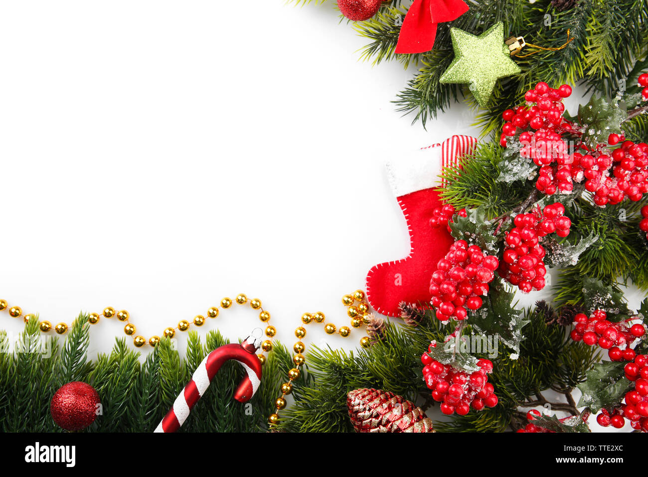 Christmas tree branch with red berries and decorations on white ...