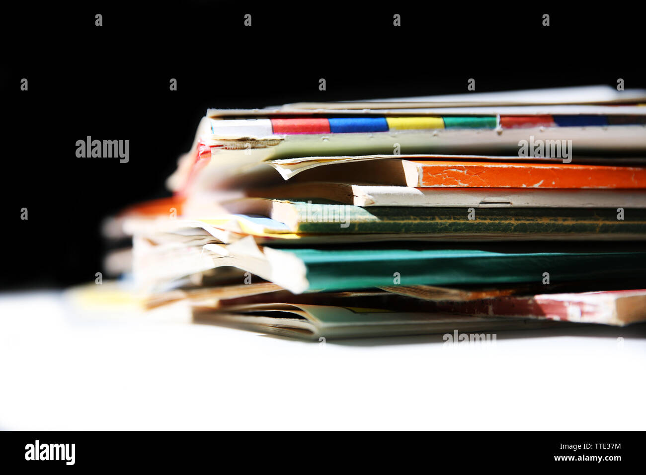 Pile of books on the table against black wall, close up Stock Photo - Alamy