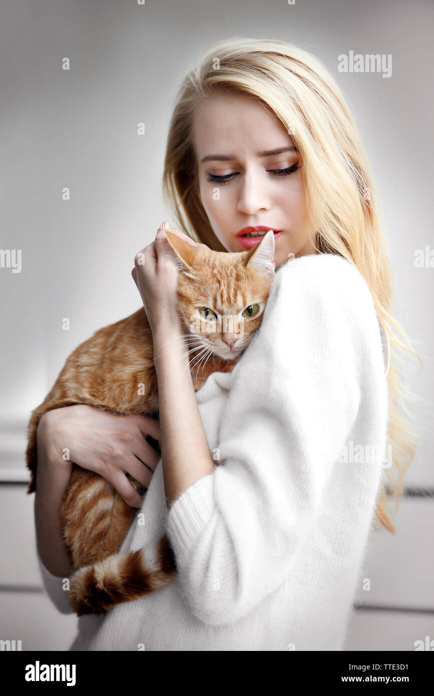 Young woman holds red cat in hands, close up Stock Photo - Alamy