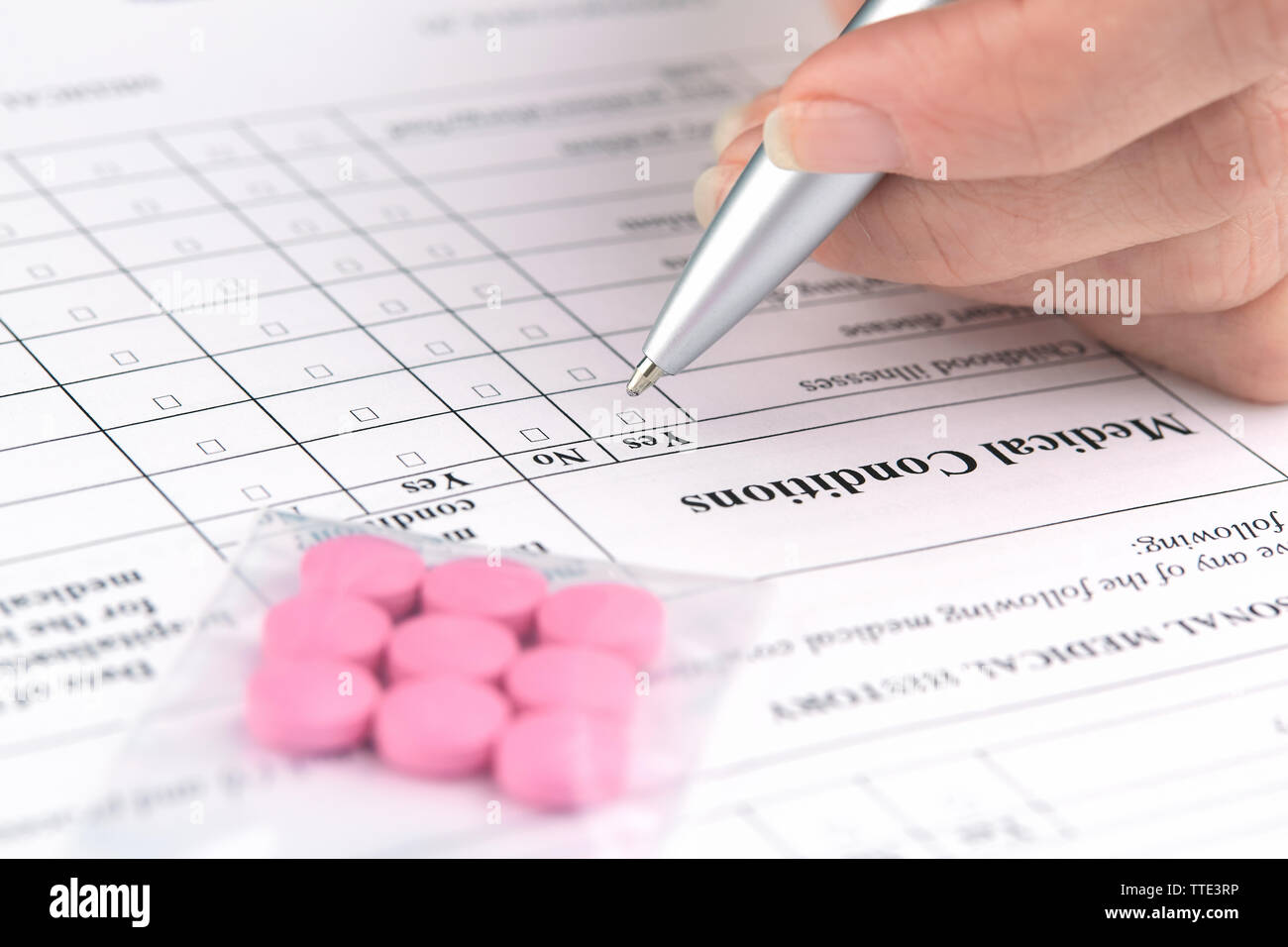 Pink pills and hand writing on medical questionnaire form Stock Photo ...