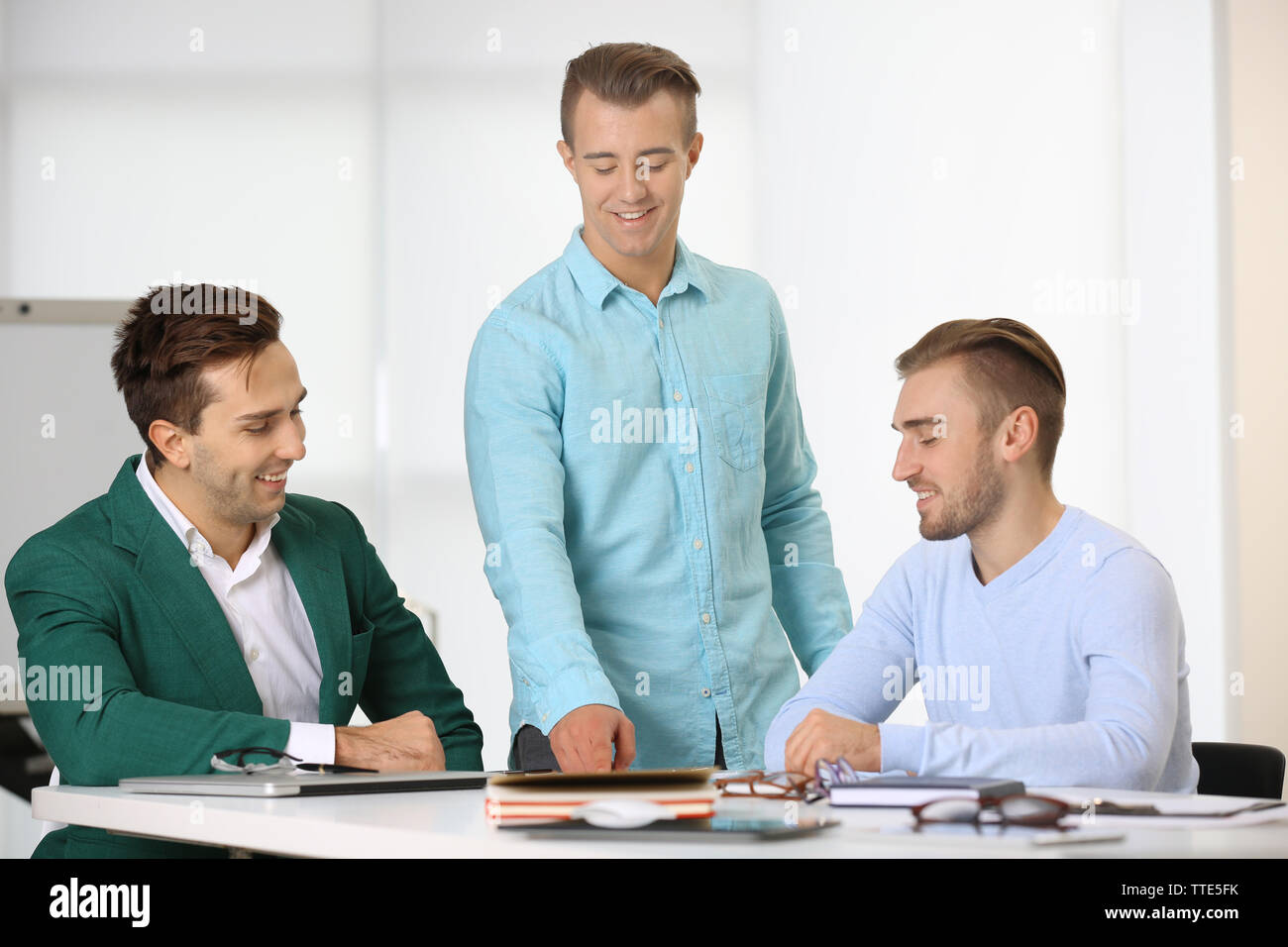 Three young business men at the meeting in a conference room Stock ...