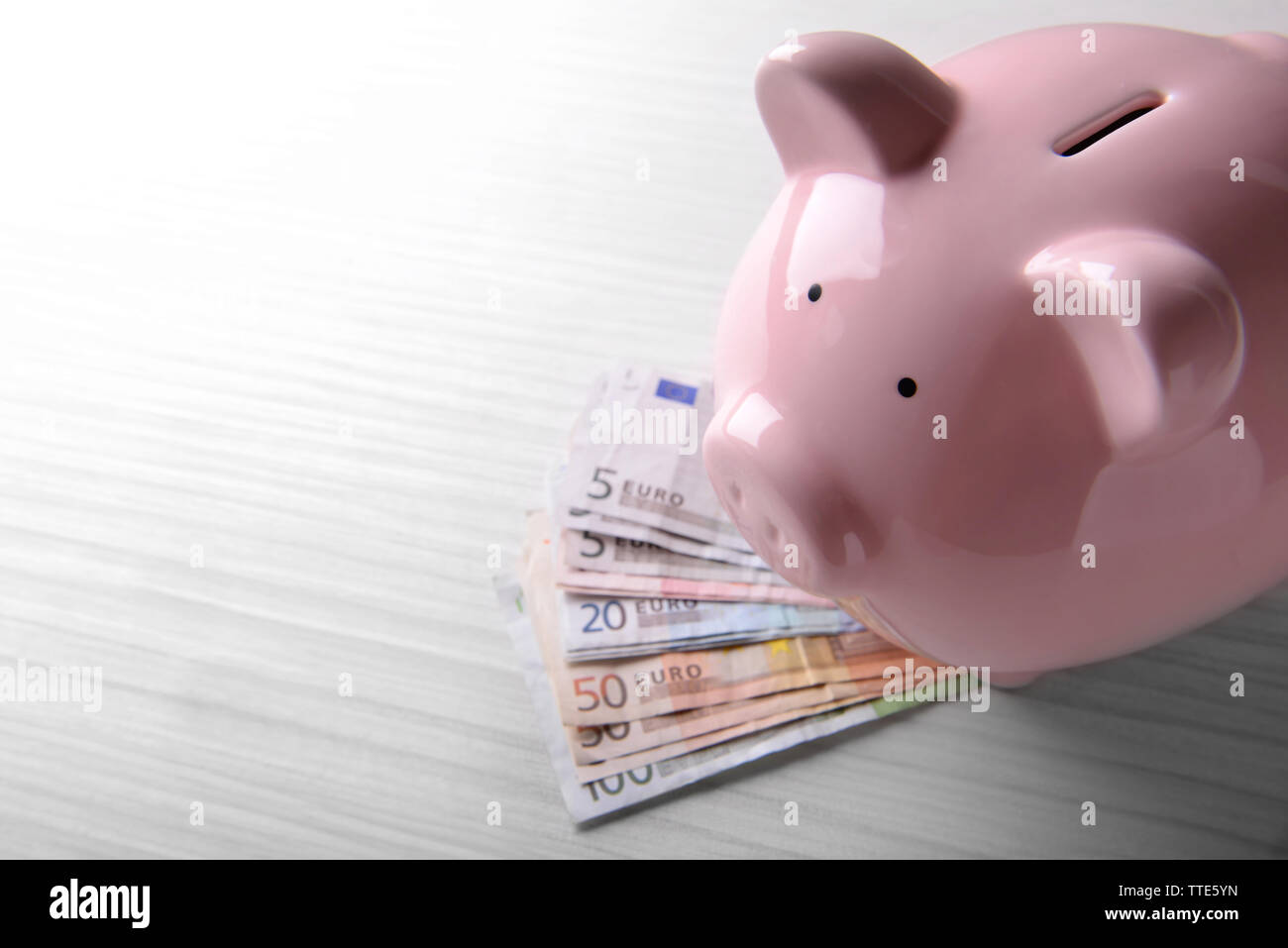 Pig moneybox and euro banknotes on wooden background Stock Photo - Alamy