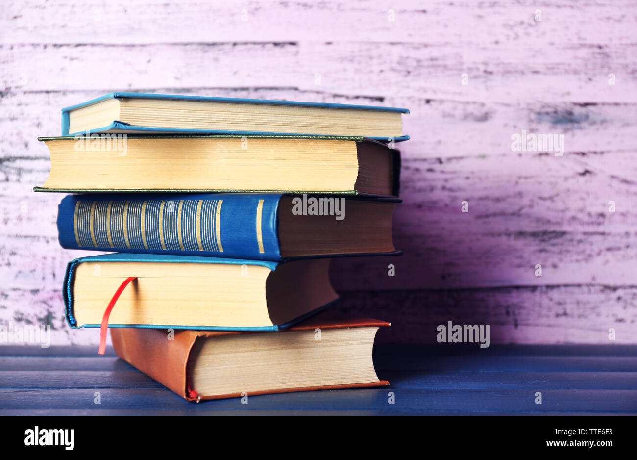 Pile of books on wooden background Stock Photo - Alamy