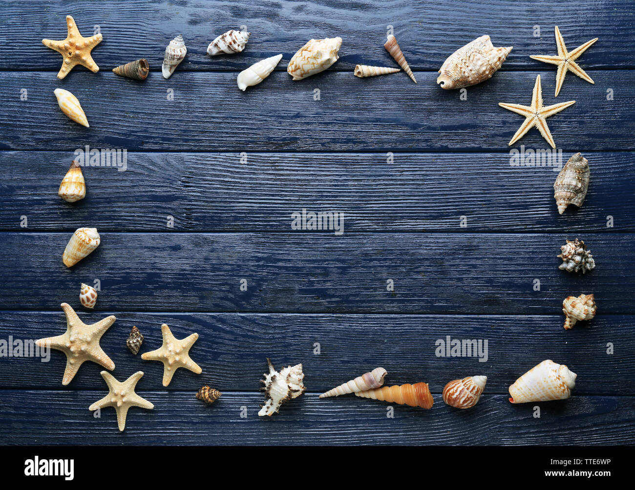Seashell frame on dark blue wooden background Stock Photo - Alamy