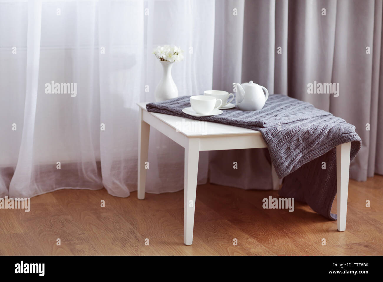 Little table in the room in front of window with curtains Stock Photo ...