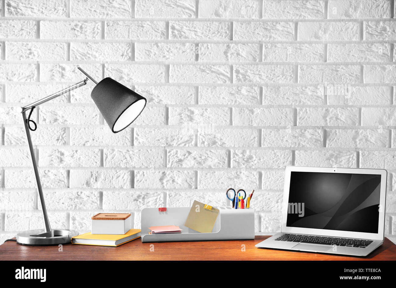 Modern workplace on brick wall background Stock Photo - Alamy