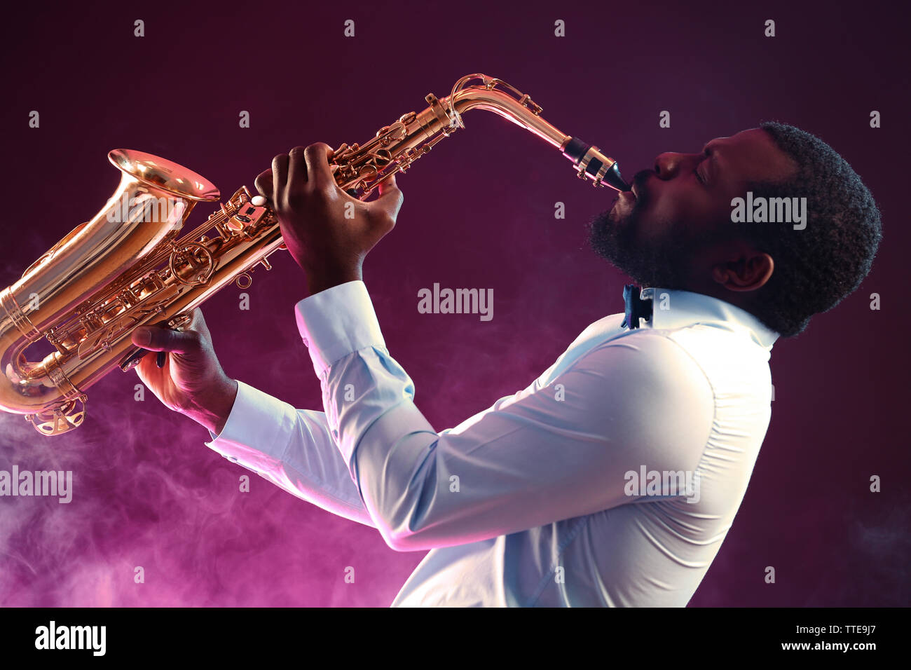 African American jazz musician playing the saxophone against colorful ...