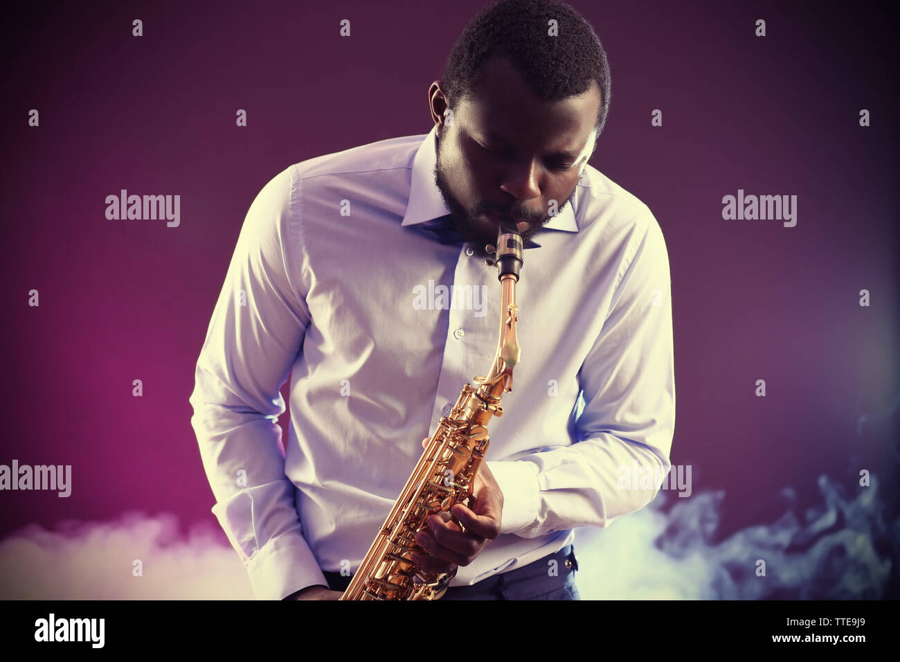 African American jazz musician playing the saxophone against colorful ...