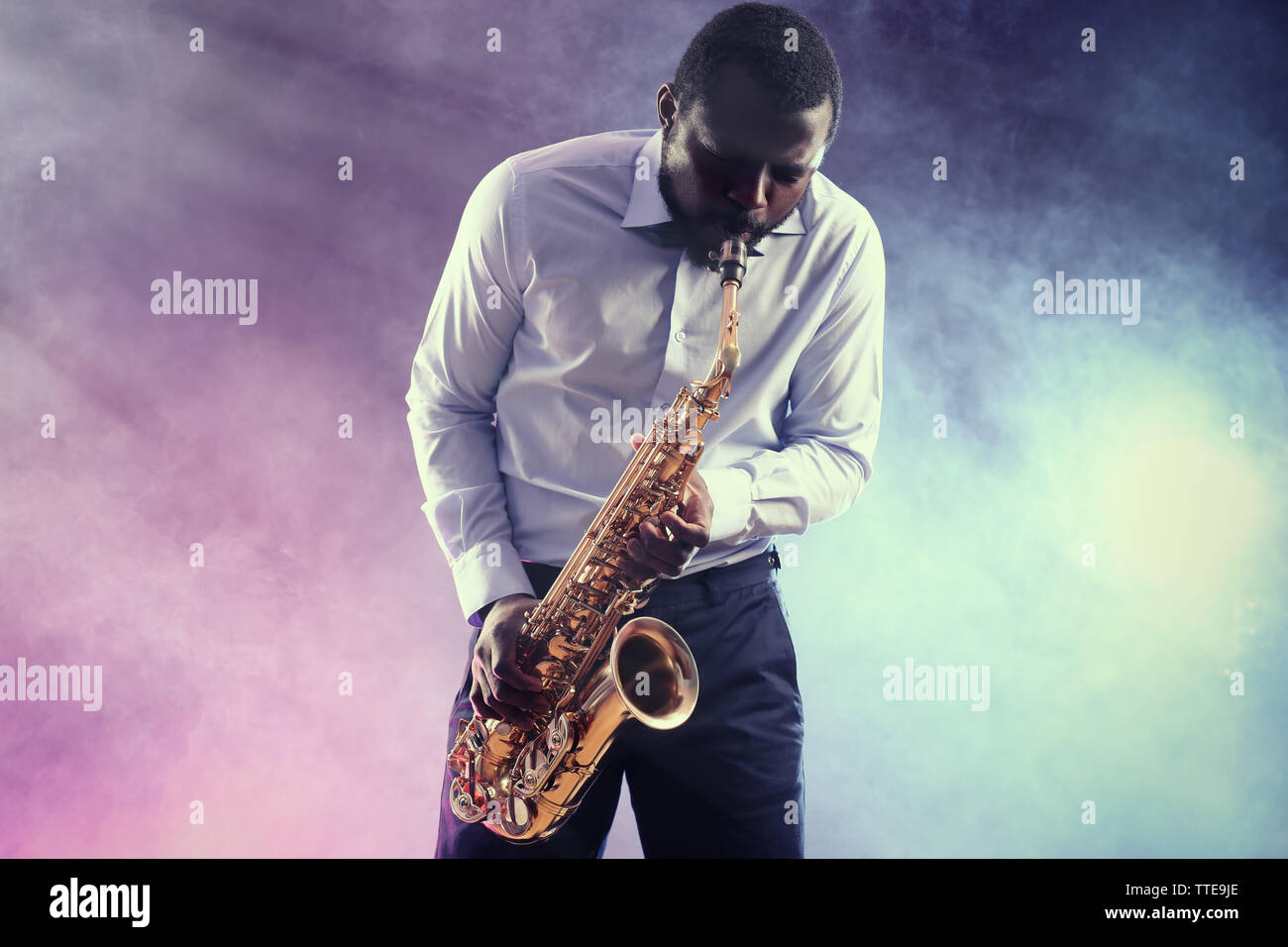 African American jazz musician playing the saxophone against colorful ...