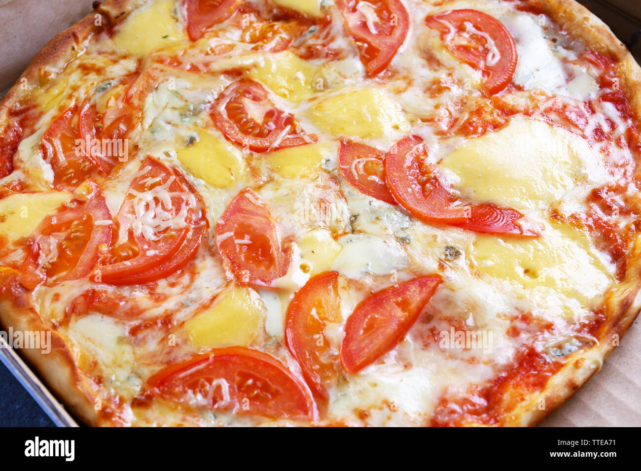 Delicious full of cheese pizza with tomatoes background Stock Photo - Alamy