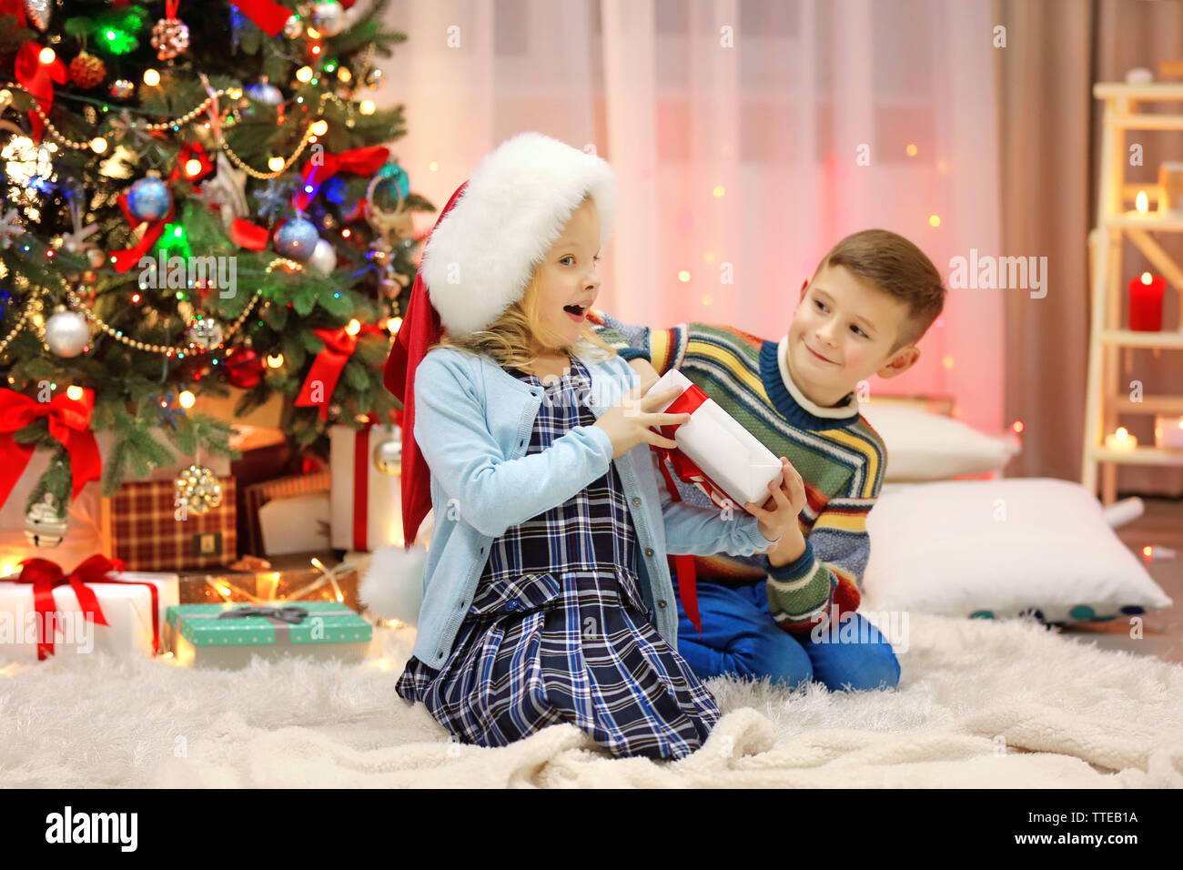 Happy children playing with gifts in the decorated Christmas room Stock ...