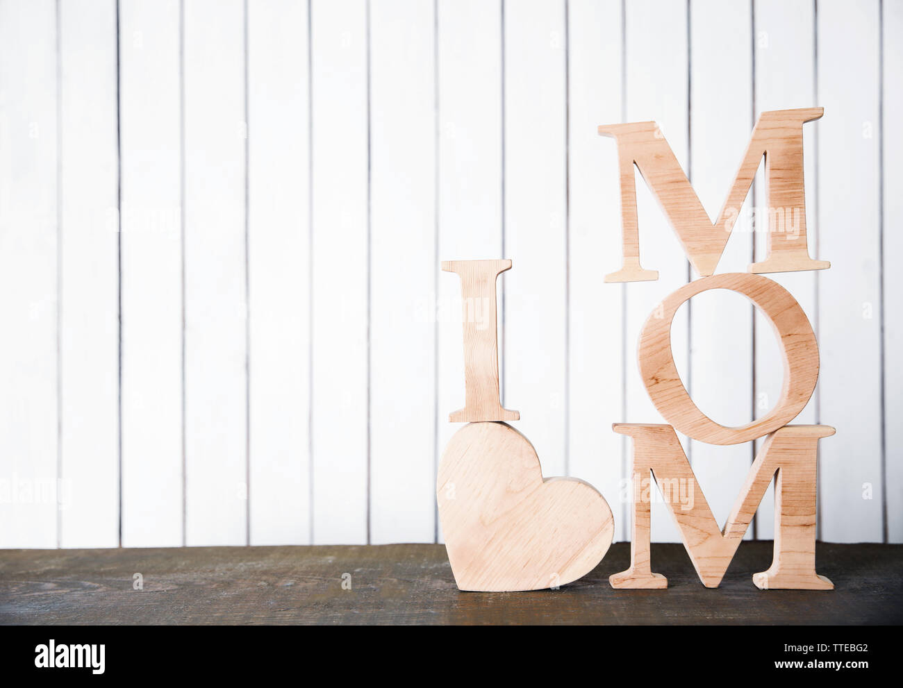 I love mom inscription of wooden letters with heart on white wall ...
