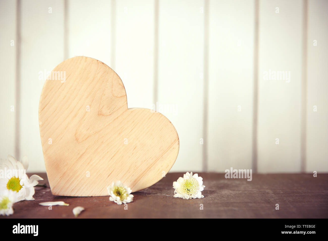 Wooden heart with flowers on a white wall background Stock Photo - Alamy