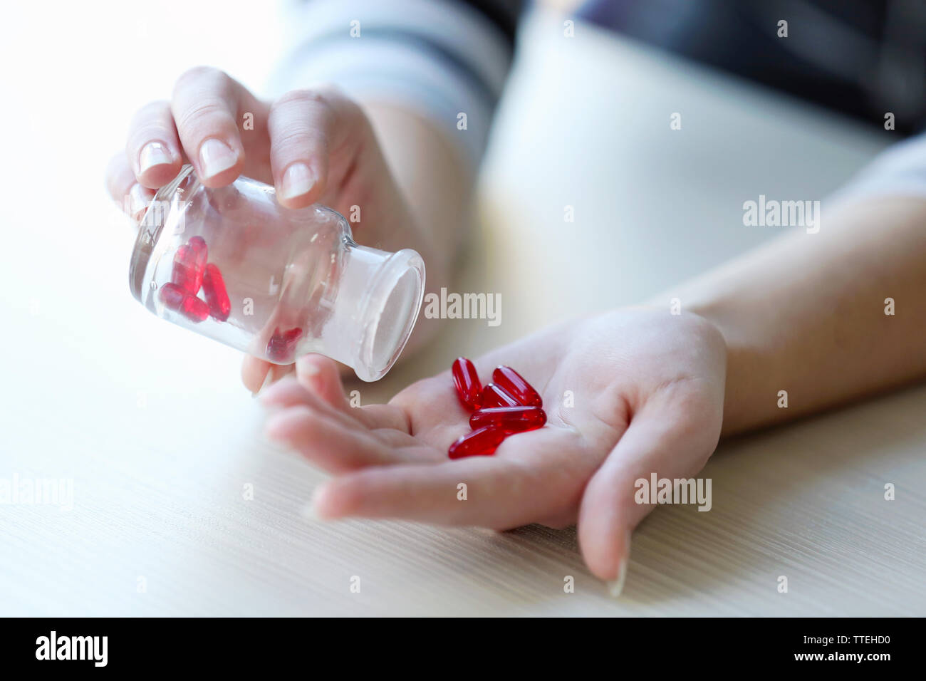 Woman spills red medical capsules to her hand, close up Stock Photo - Alamy