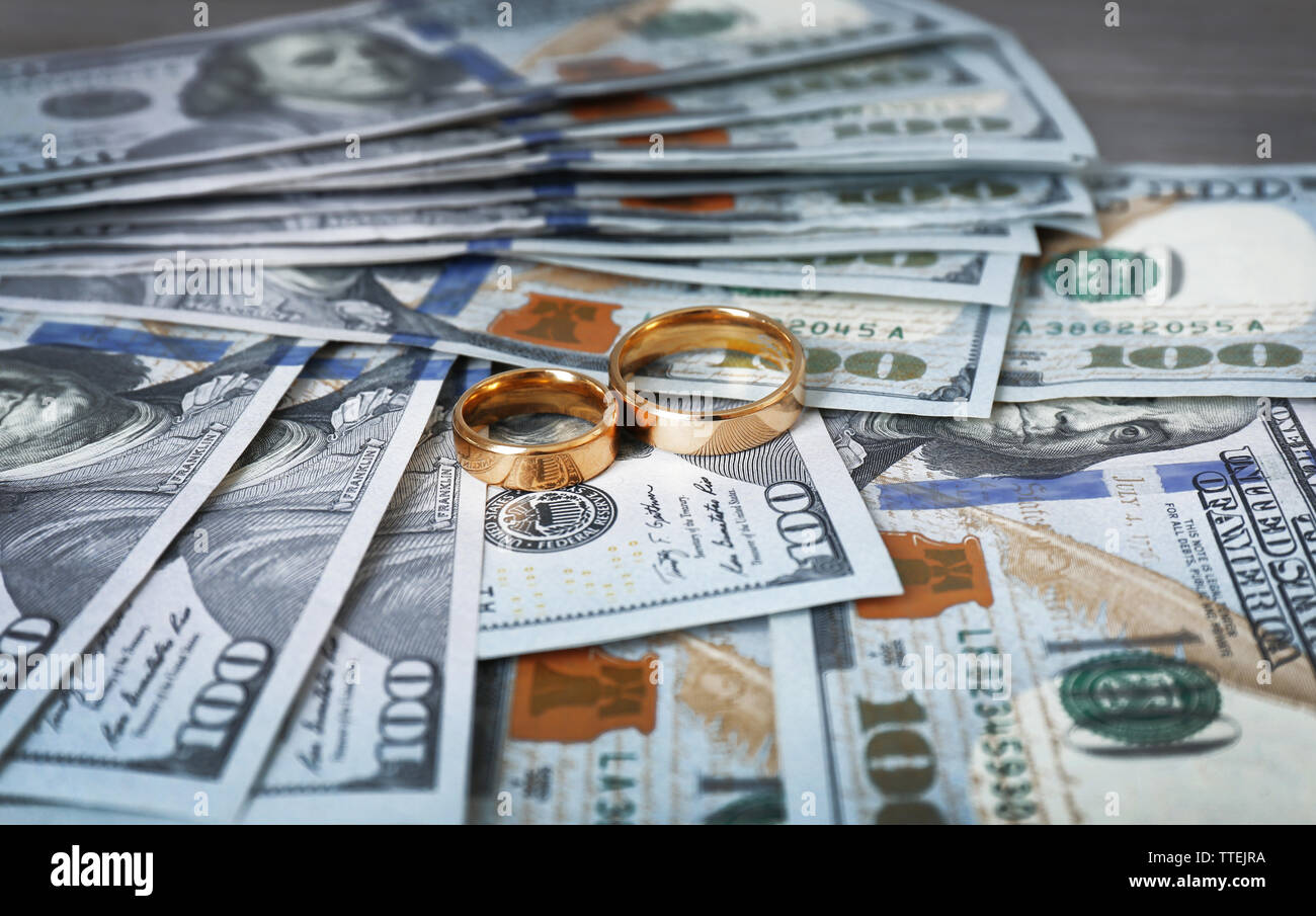 Wedding rings on money background, close up Stock Photo - Alamy