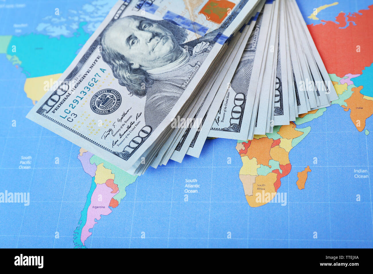 Cash on the world map background, close up Stock Photo - Alamy