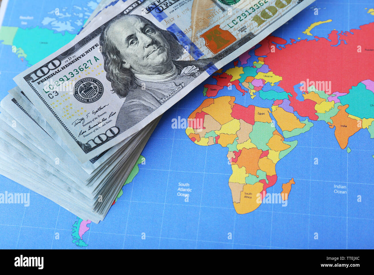 Cash on the world map background, close up Stock Photo - Alamy