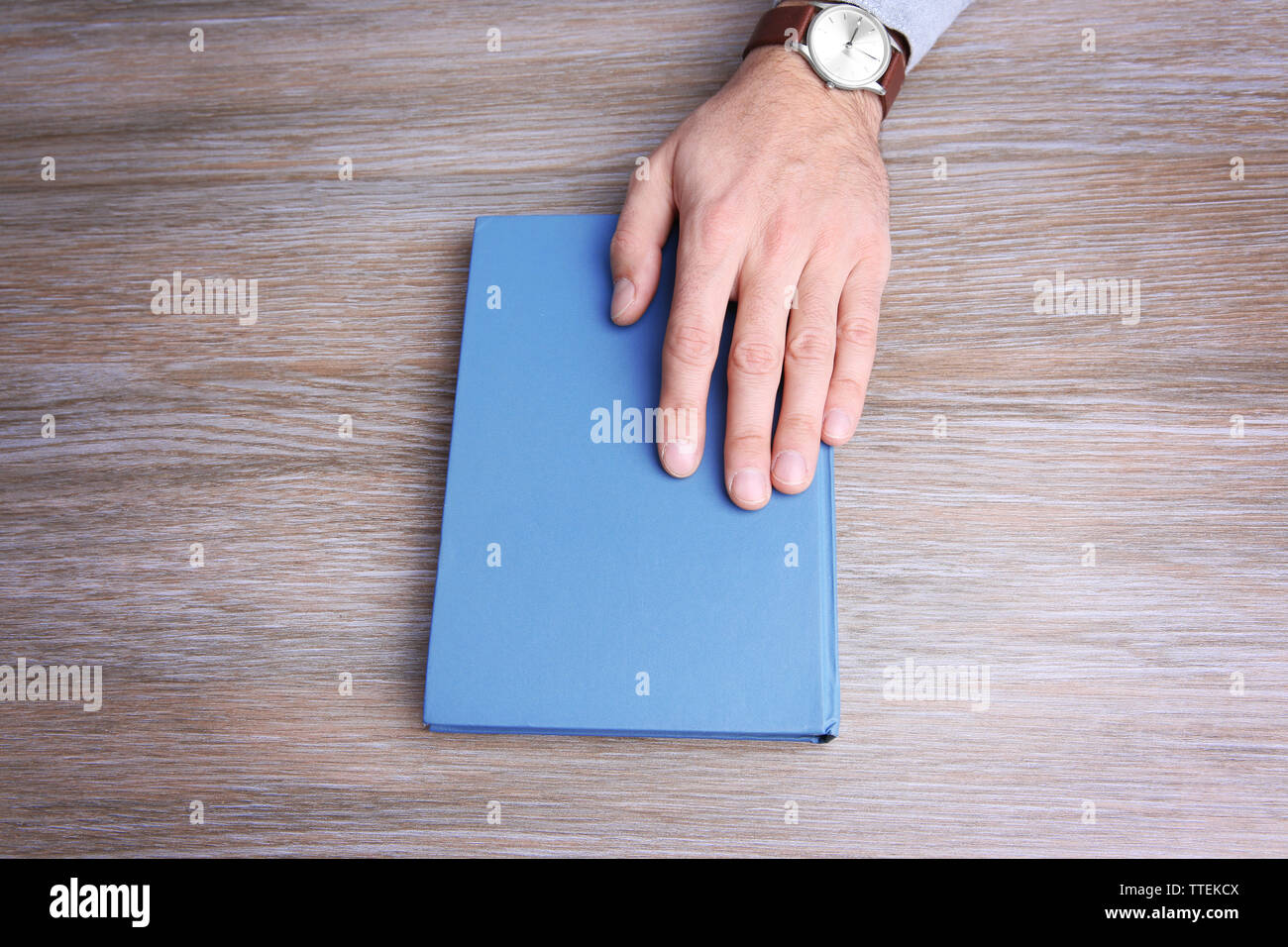 Man hand on book, on wooden table background Stock Photo - Alamy
