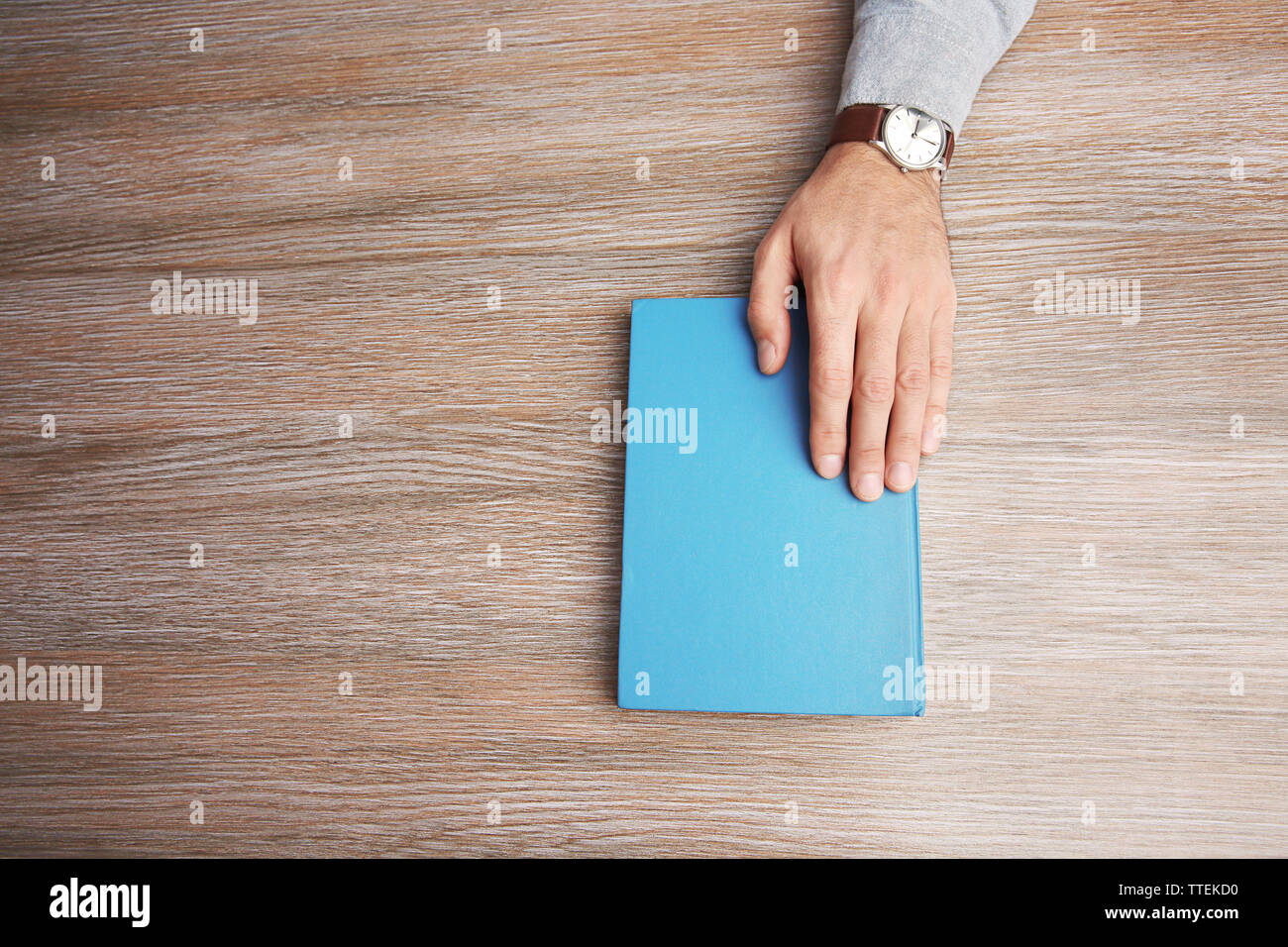 Man hand on book, on wooden table background Stock Photo - Alamy