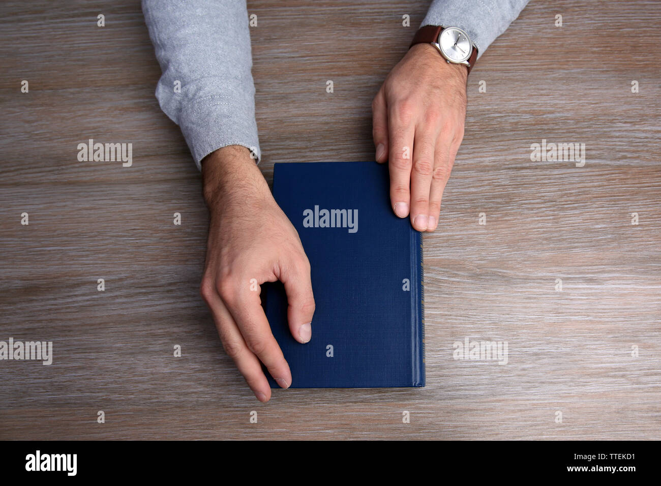 Man hands holding book, on wooden table background Stock Photo - Alamy