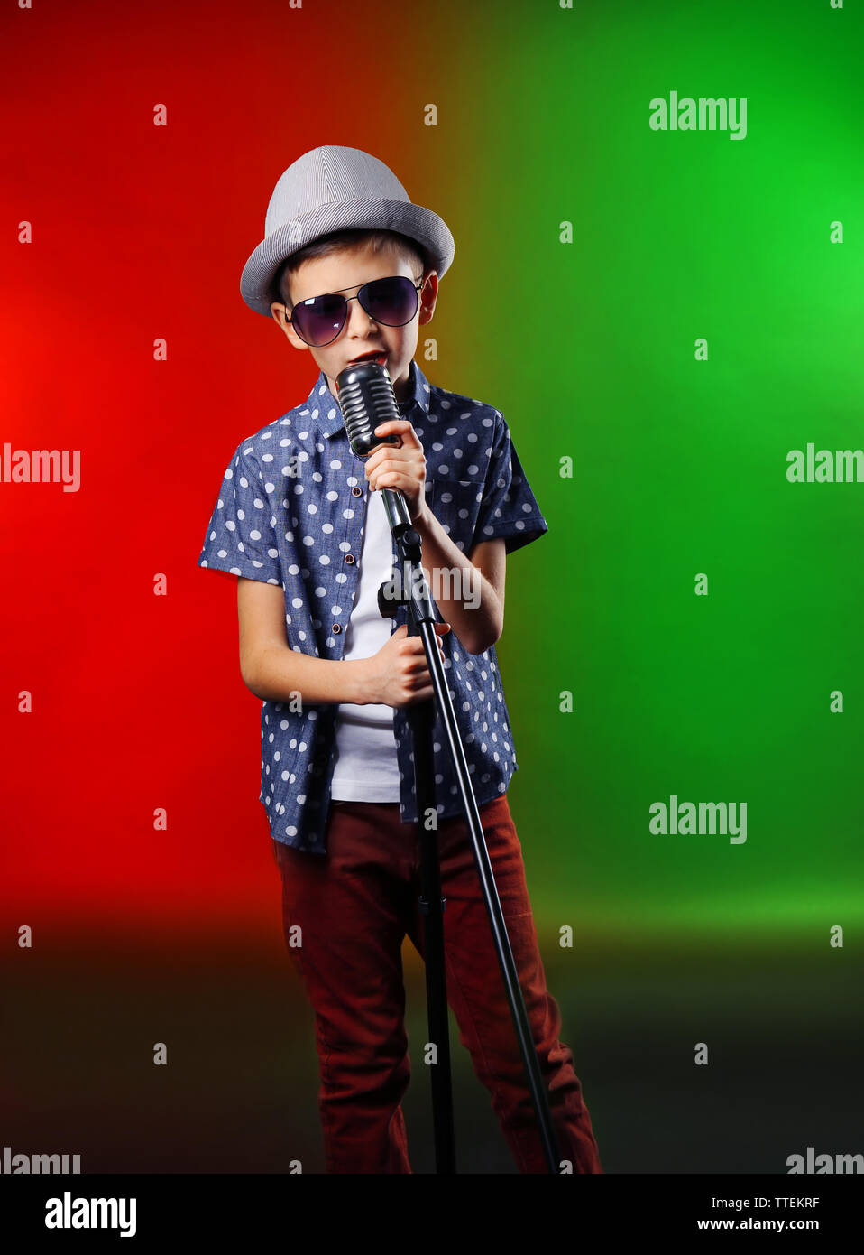 Little boy singing with microphone on a bright background Stock Photo ...