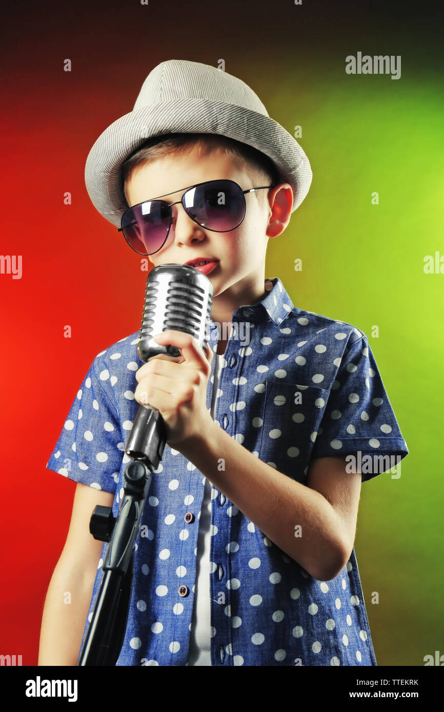 Little boy singing with microphone on a bright background Stock Photo ...