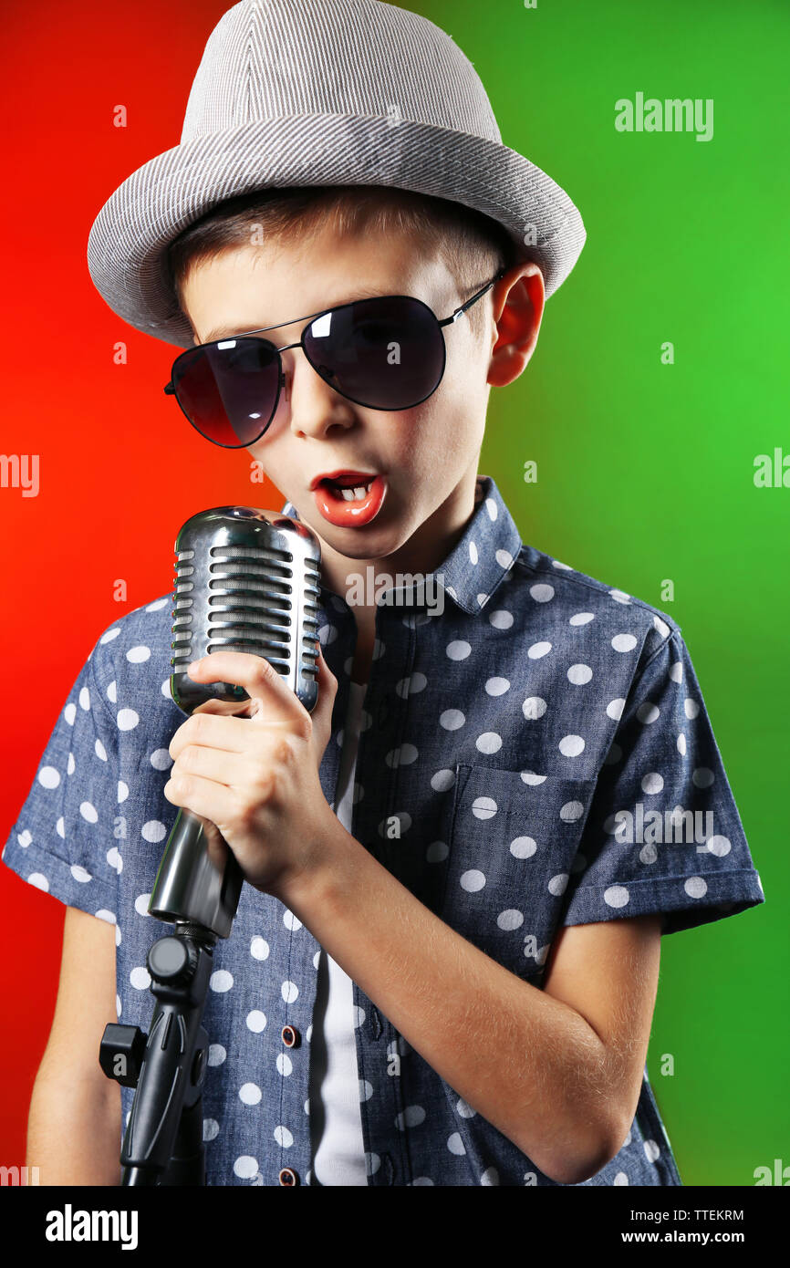 Little boy singing with microphone on a bright background Stock Photo ...