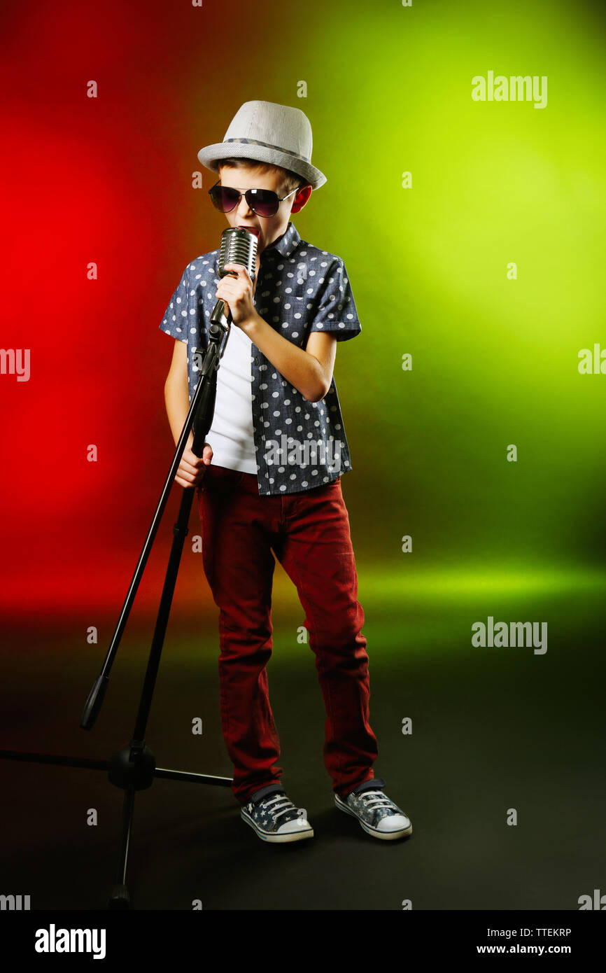 Little boy singing with microphone on a bright background Stock Photo ...