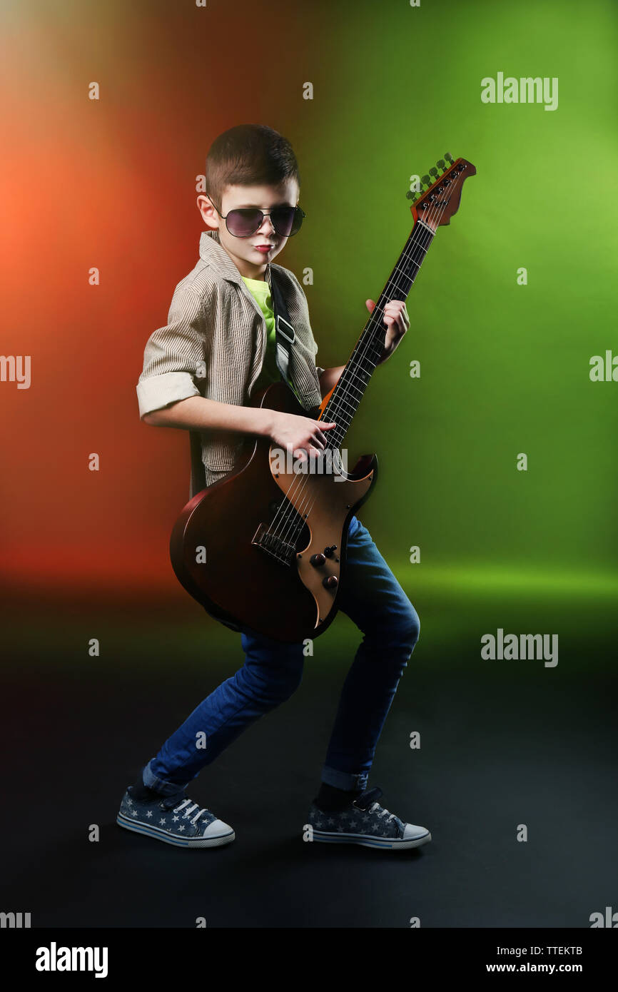 Little boy playing guitar on a bright background Stock Photo - Alamy
