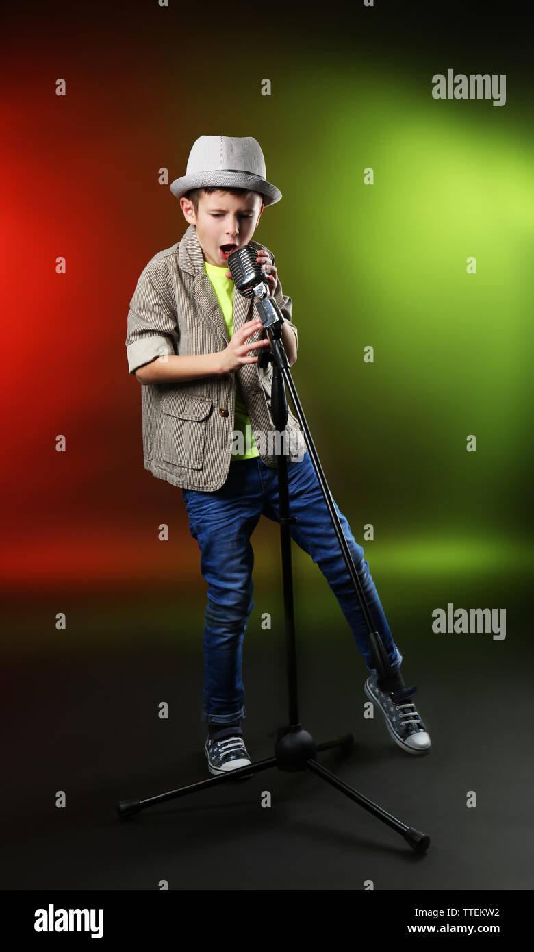 Little boy singing with microphone on a bright background Stock Photo ...
