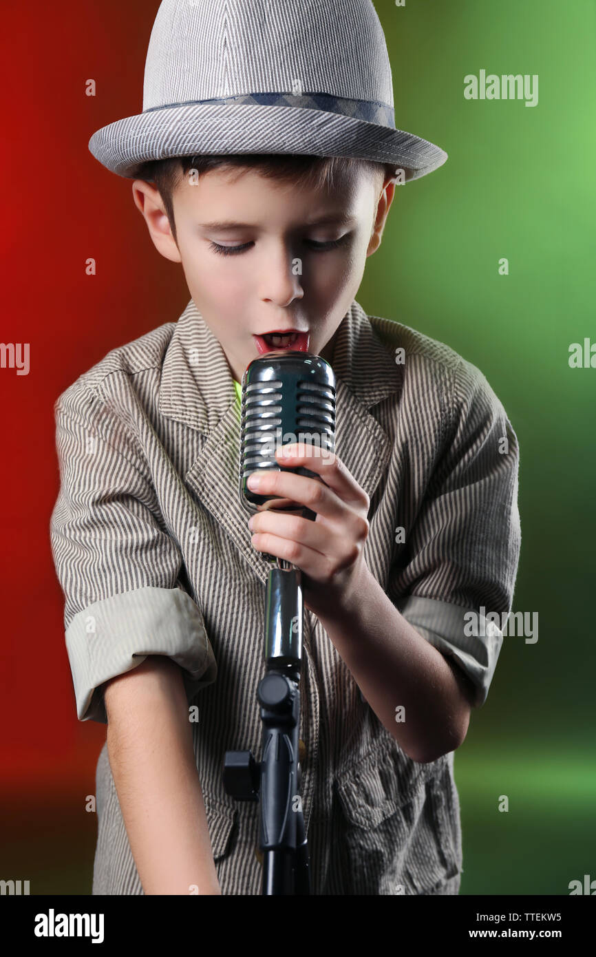 Little boy singing with microphone on a bright background Stock Photo ...