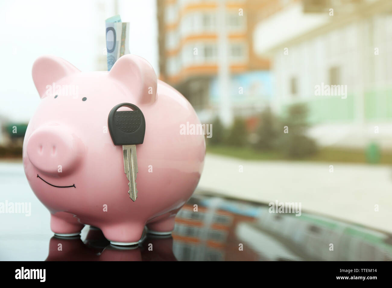 Piggy money box with cash and key on car bonnet at the street Stock ...