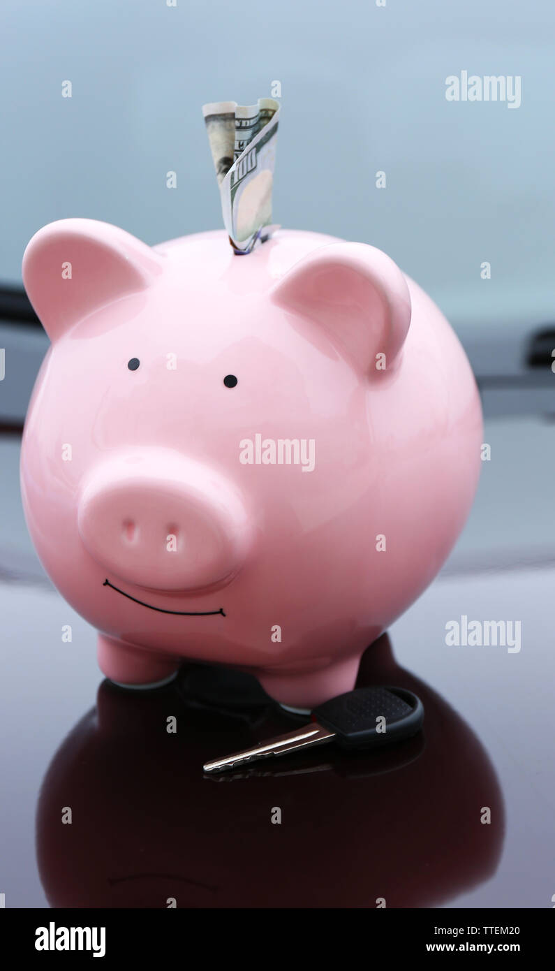 Piggy money box with cash and key on car bonnet at the street Stock ...