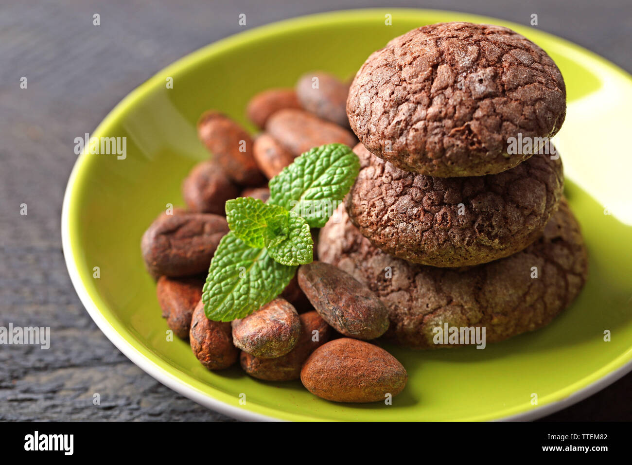 Chocolate chip cookie with yellow stripe and mint in plate, closeup ...
