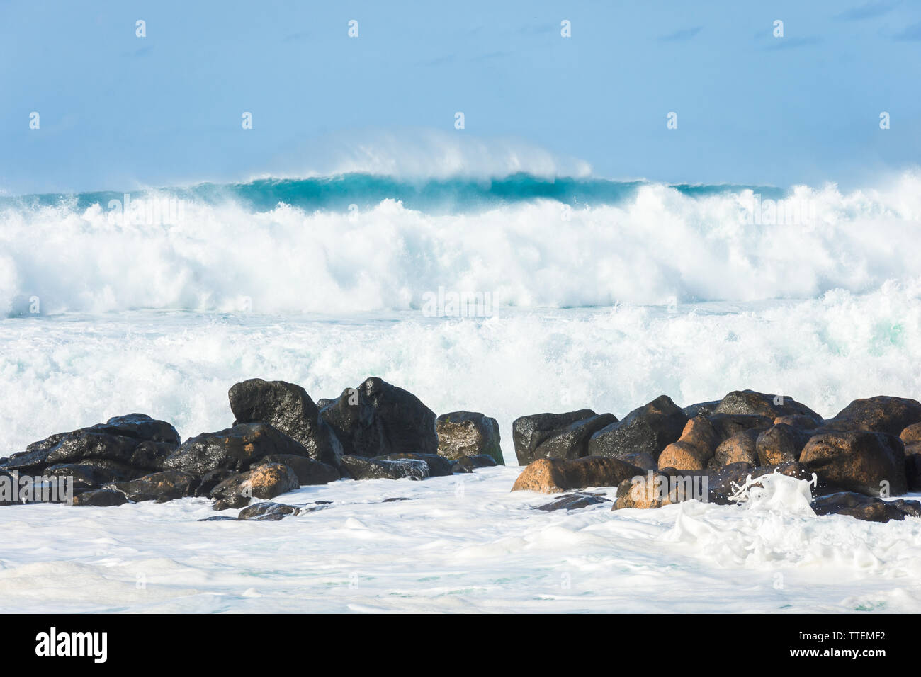 Giant blue waves crashing into large rocks near the Banzai Pipeline on ...