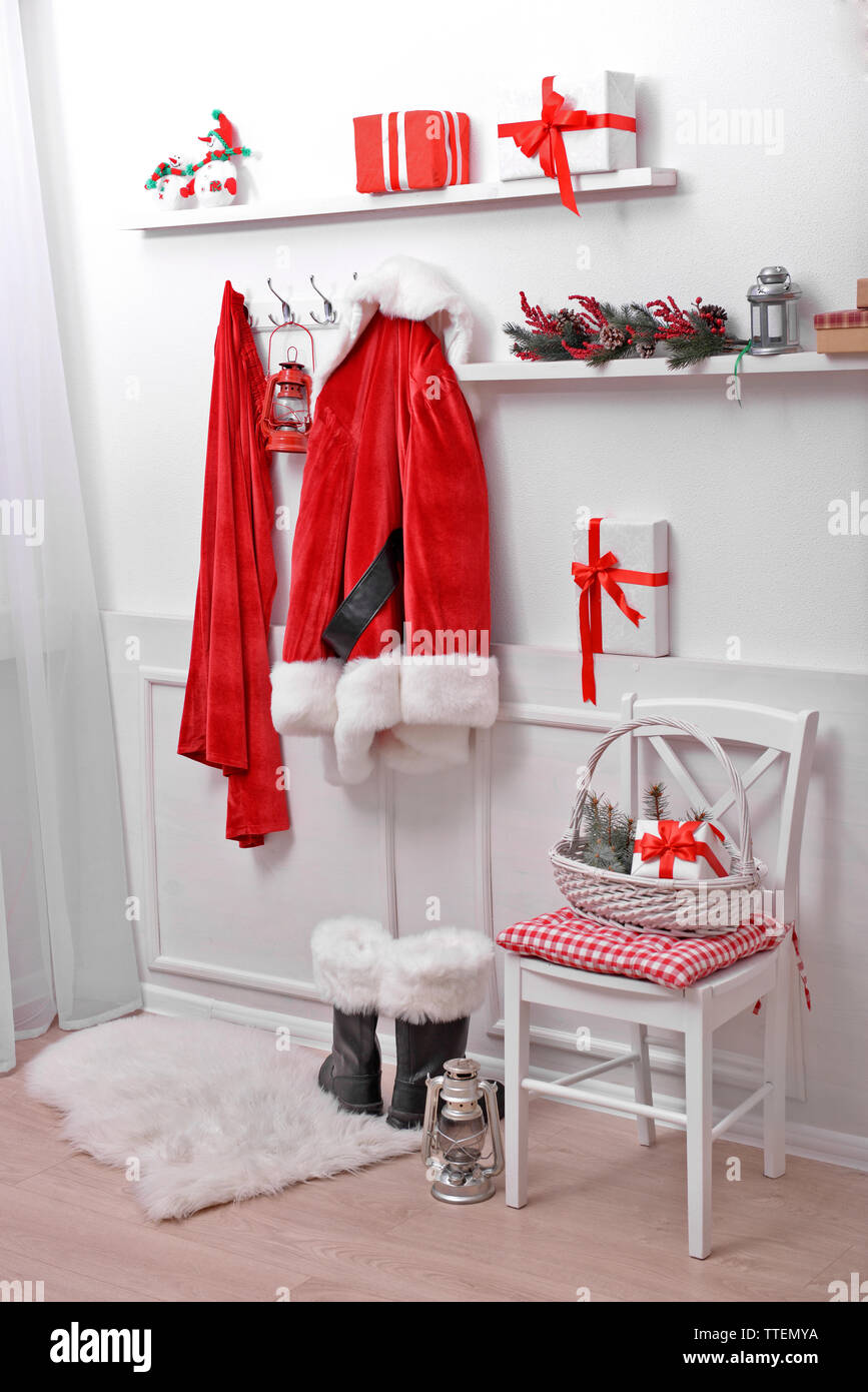 Santa costume hanging in white room Stock Photo - Alamy