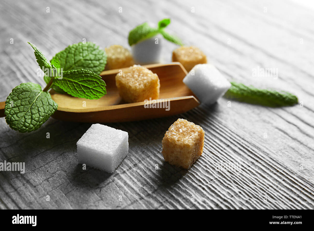 Pile of brown sugar cubes and stevia on grey wooden background Stock ...