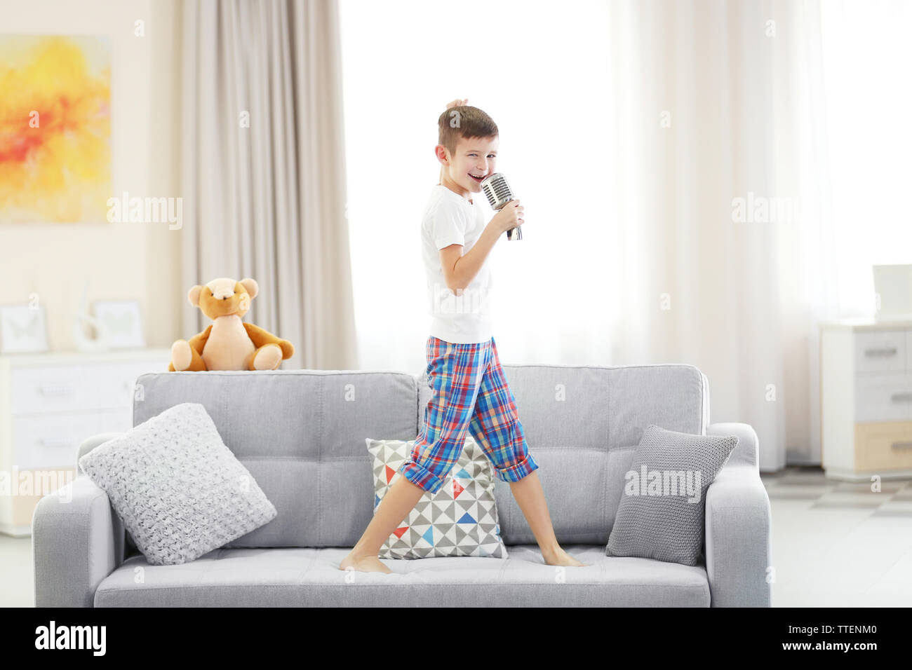 Little boy singing with a microphone on a sofa at home Stock Photo - Alamy