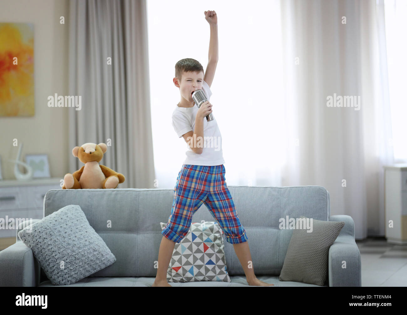 Little boy singing with a microphone on a sofa at home Stock Photo - Alamy