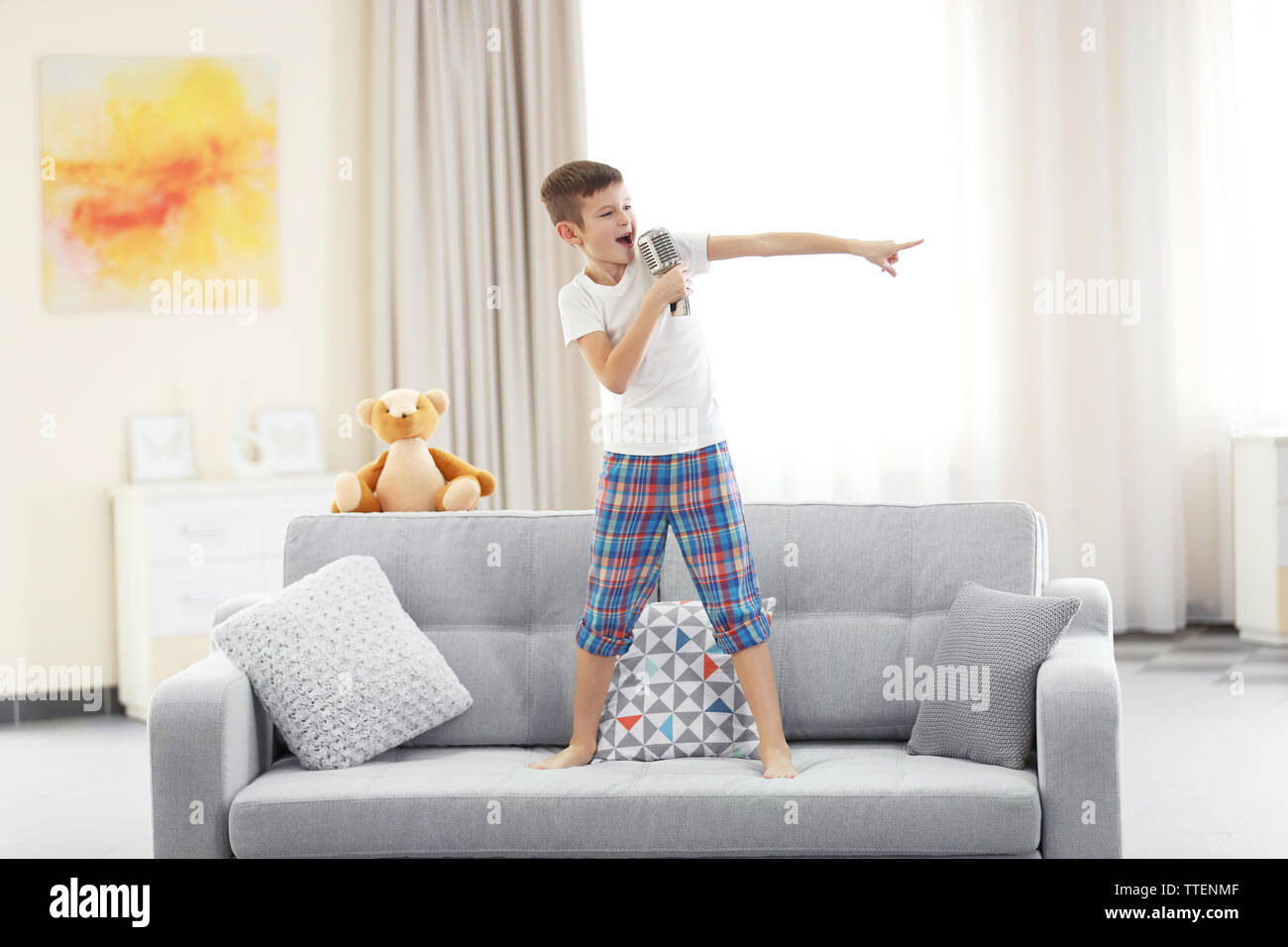 Little boy singing with a microphone on a sofa at home Stock Photo - Alamy