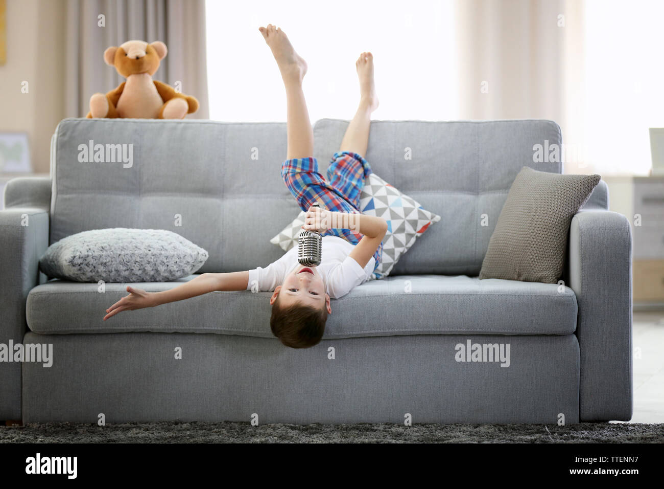 Little boy singing with a microphone on a sofa at home Stock Photo - Alamy
