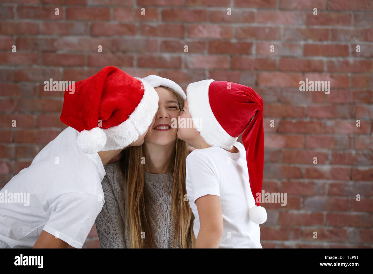 Happy cousins on brick wall background Stock Photo - Alamy