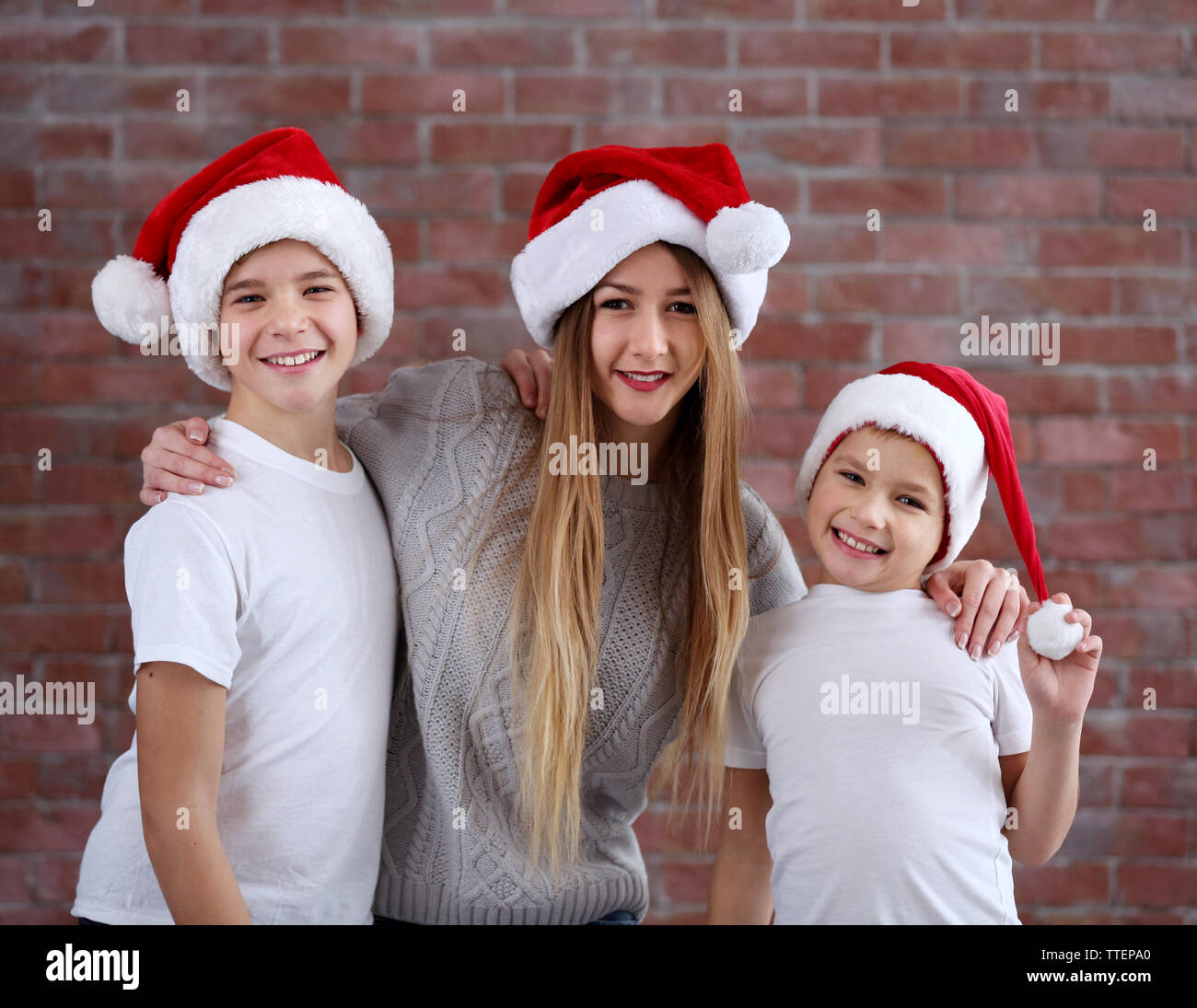 Happy cousins on brick wall background Stock Photo - Alamy