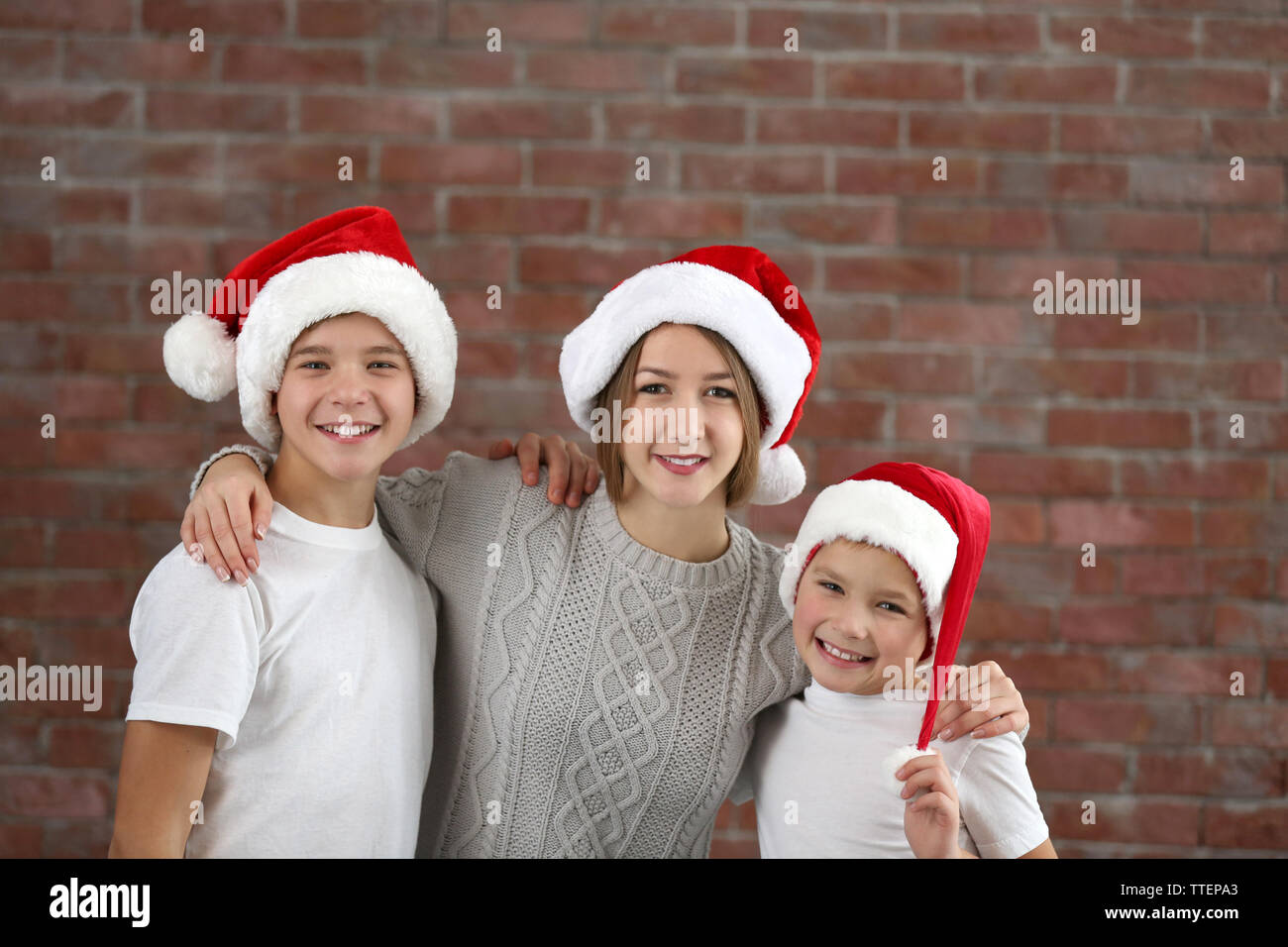 Happy cousins on brick wall background Stock Photo - Alamy