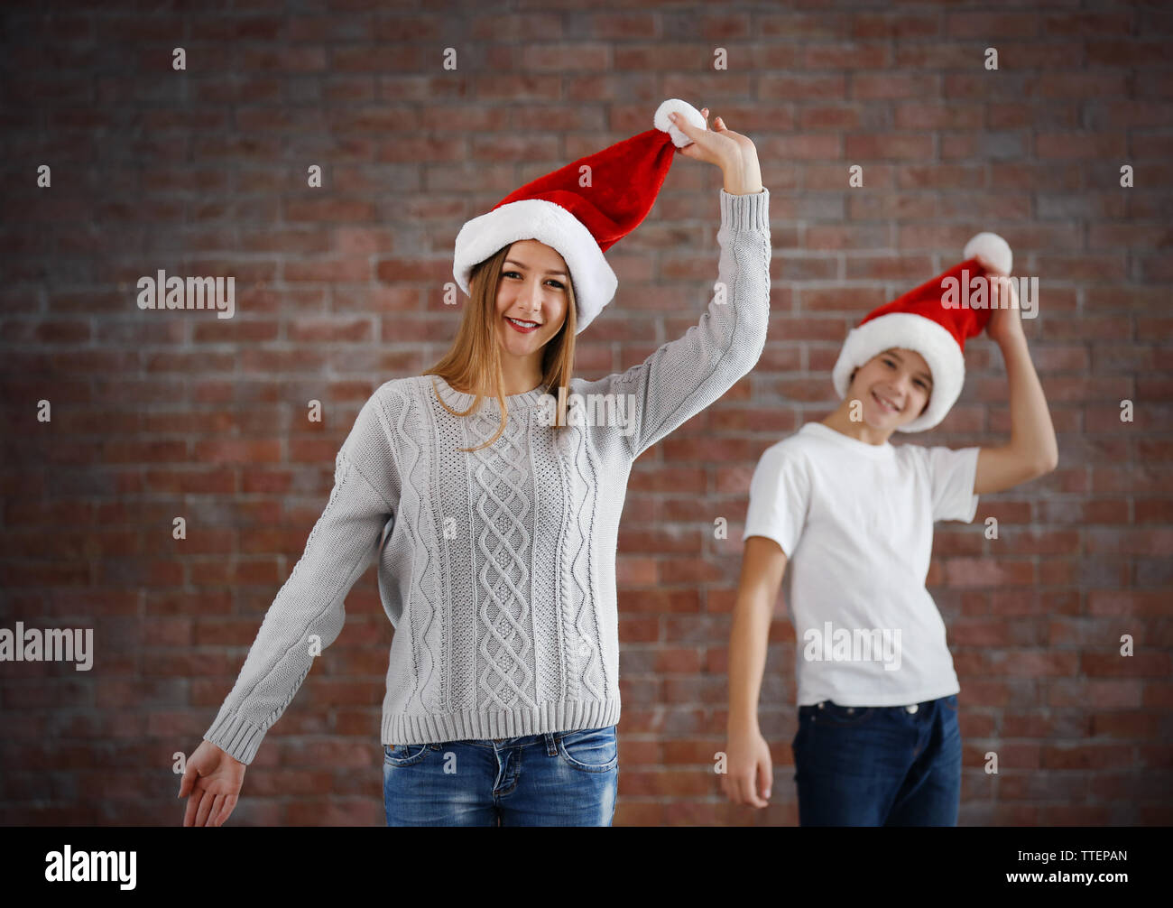 Happy cousins have fun on brick wall background Stock Photo - Alamy
