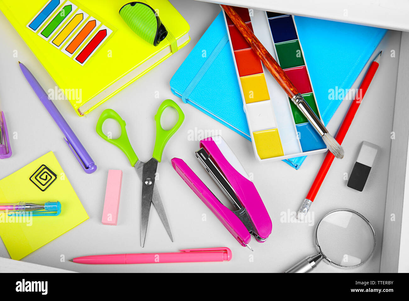 Stationery in open desk drawer, top view Stock Photo - Alamy