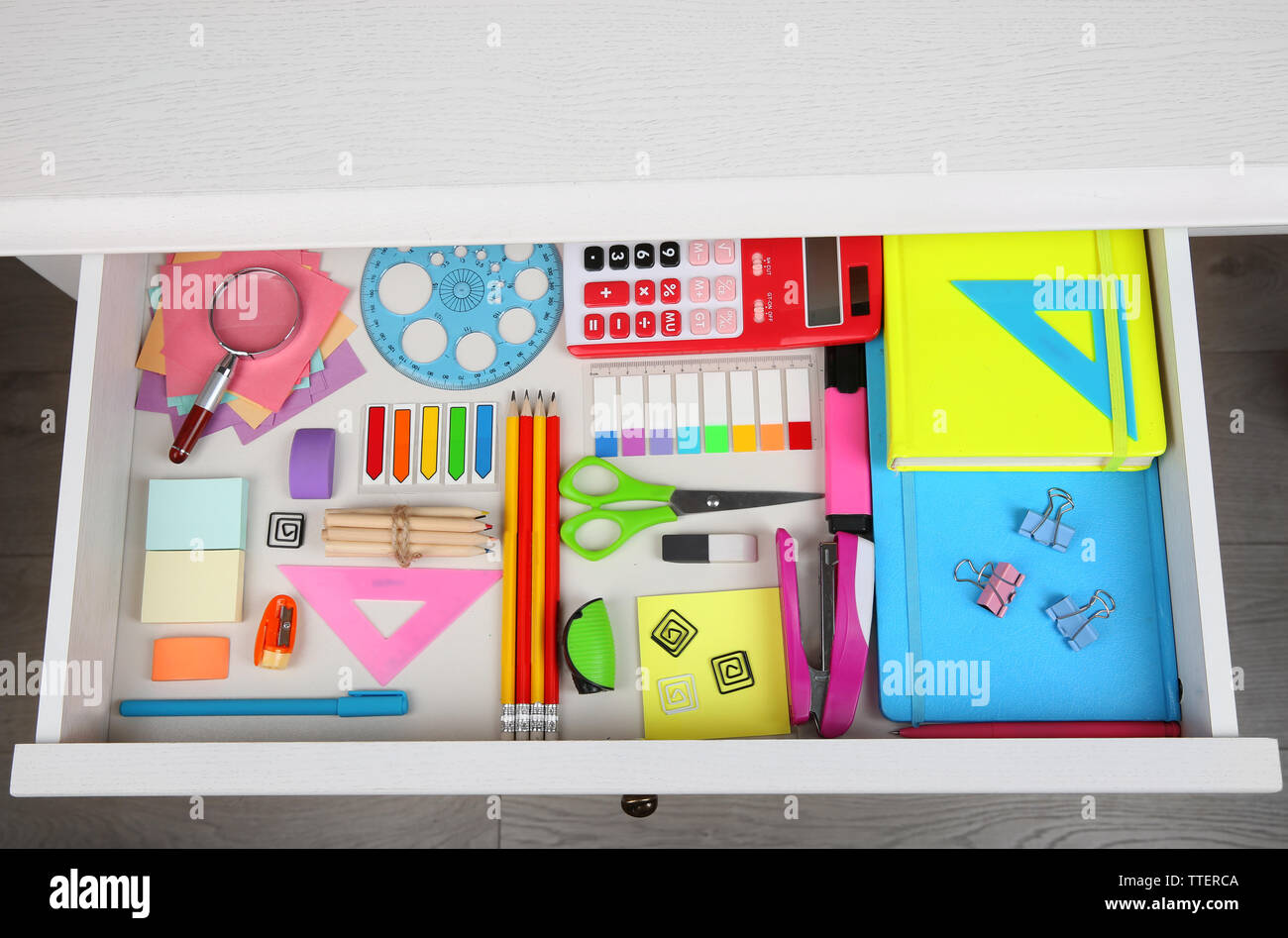 Stationery in open desk drawer, top view Stock Photo - Alamy