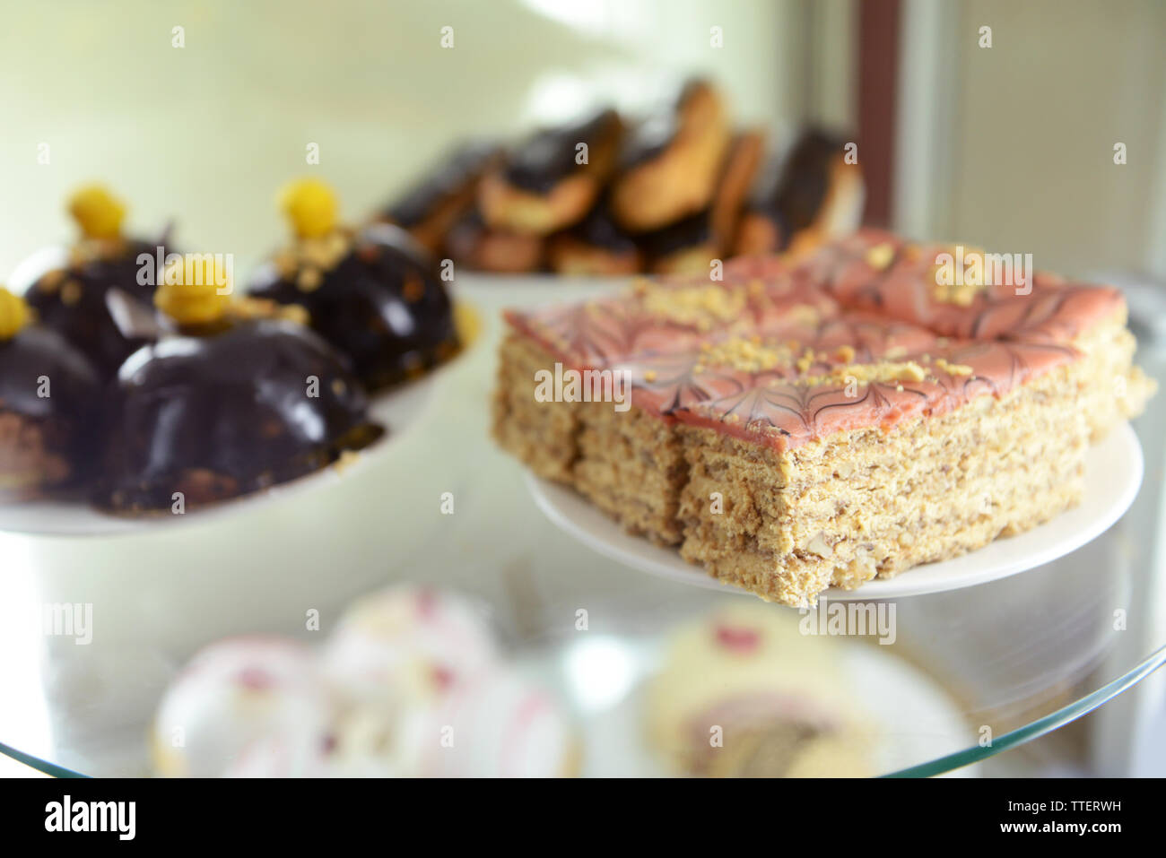 Delicious cakes on glass shelf in confectionery close up Stock Photo ...